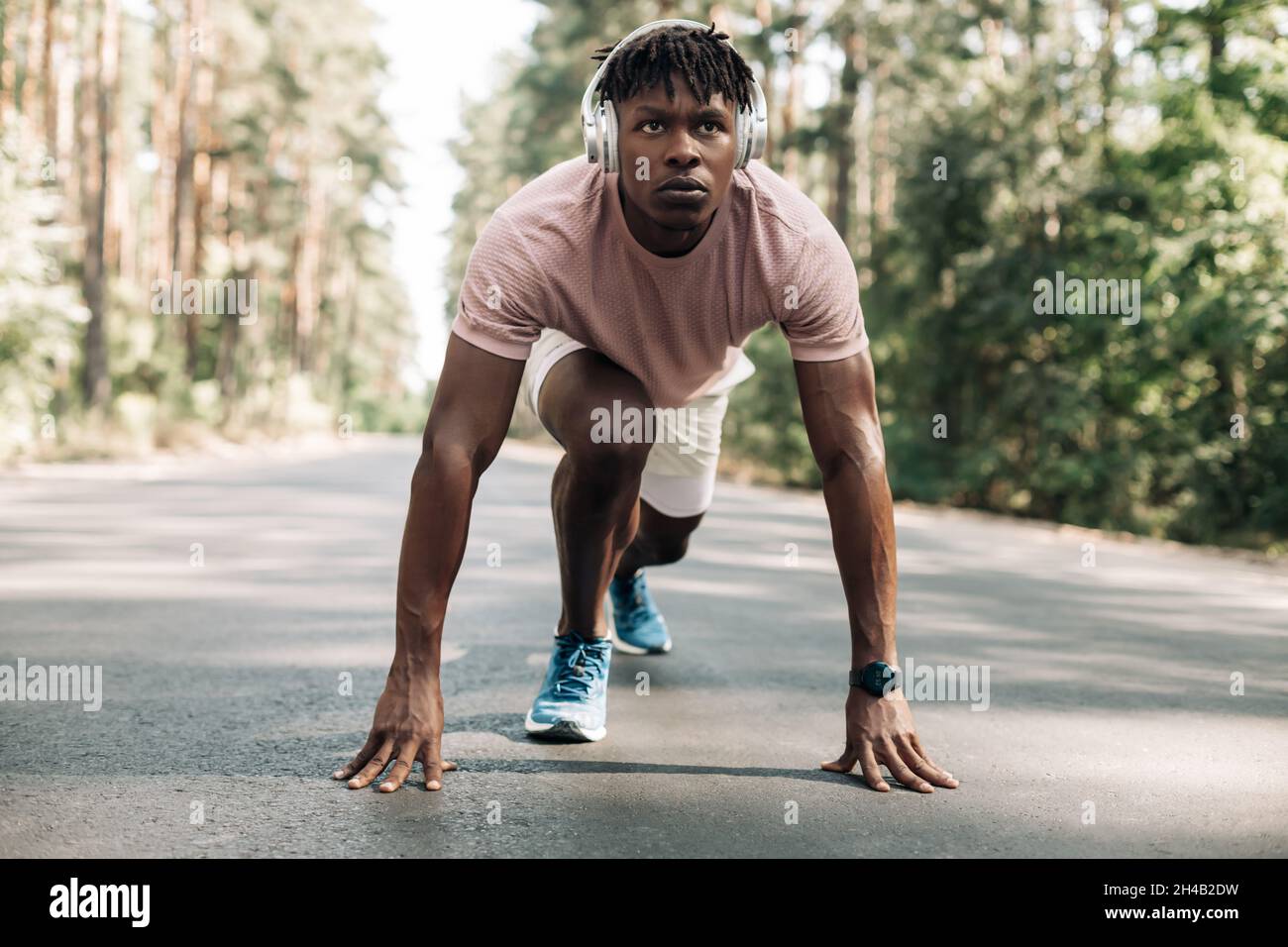 Fit black male sprinter, in starting position ready to run, Male ...