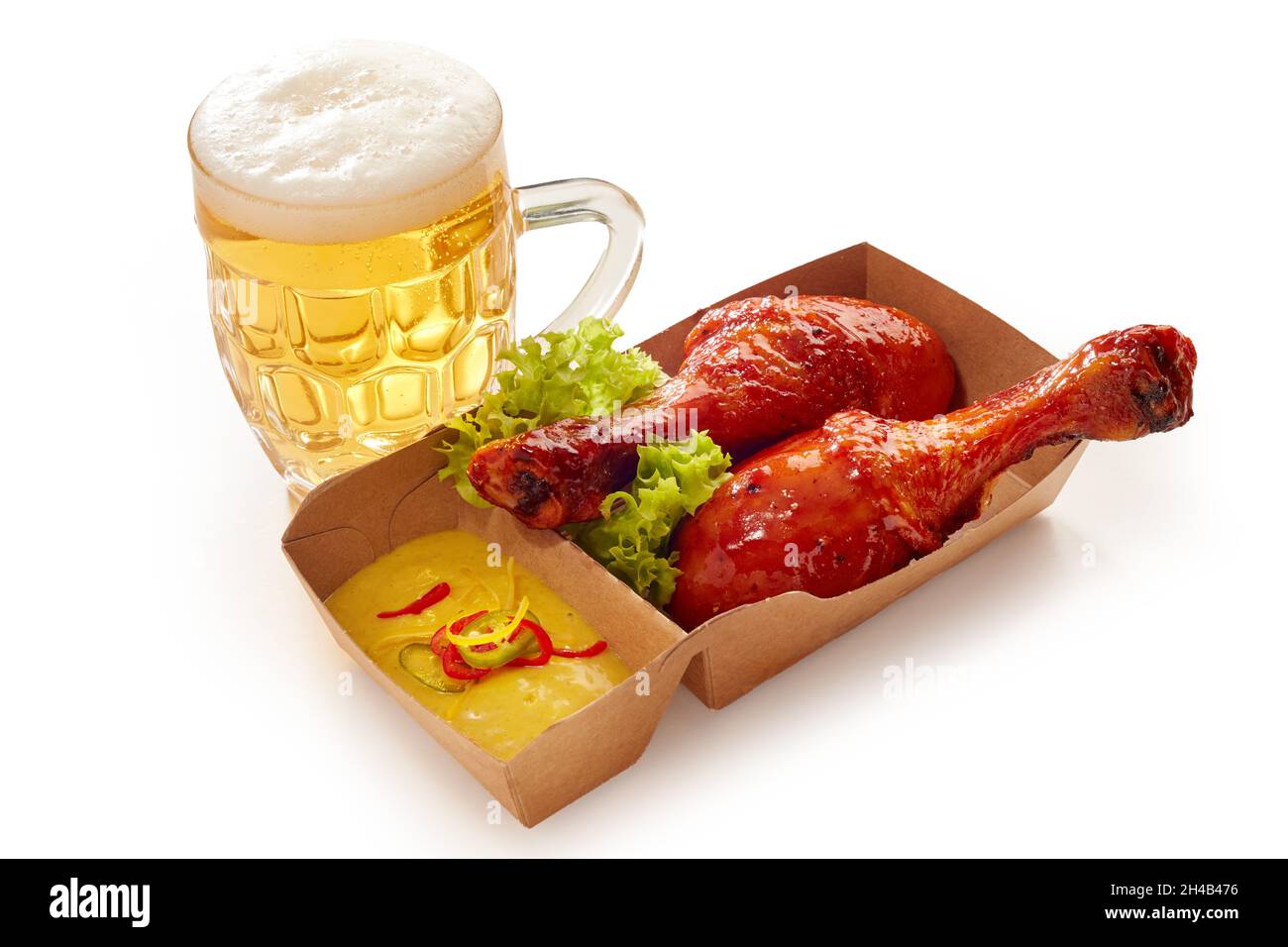 Barbeque chicken legs with mustard in carton container and a glass of ...