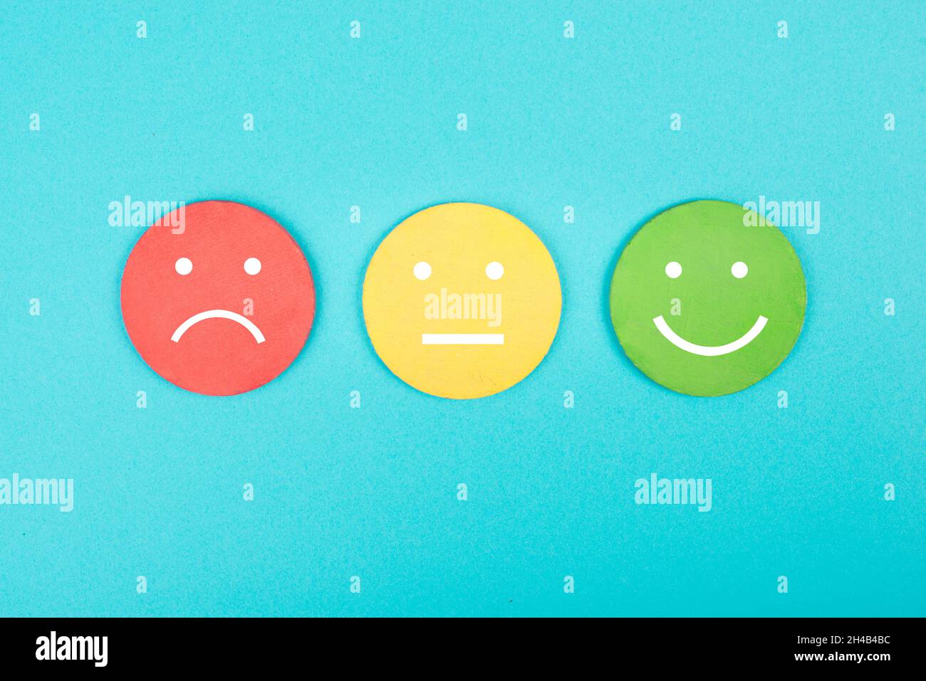 Three faces, smiling, sad in different colors on a unicolor background ...
