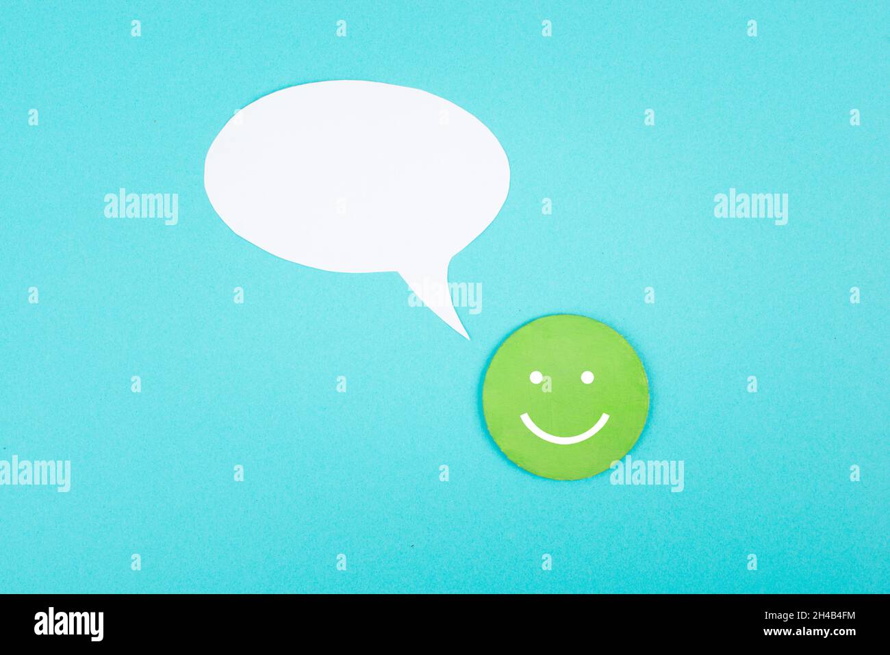 Smiling face with a speech bubble, blue colored background, copy space ...