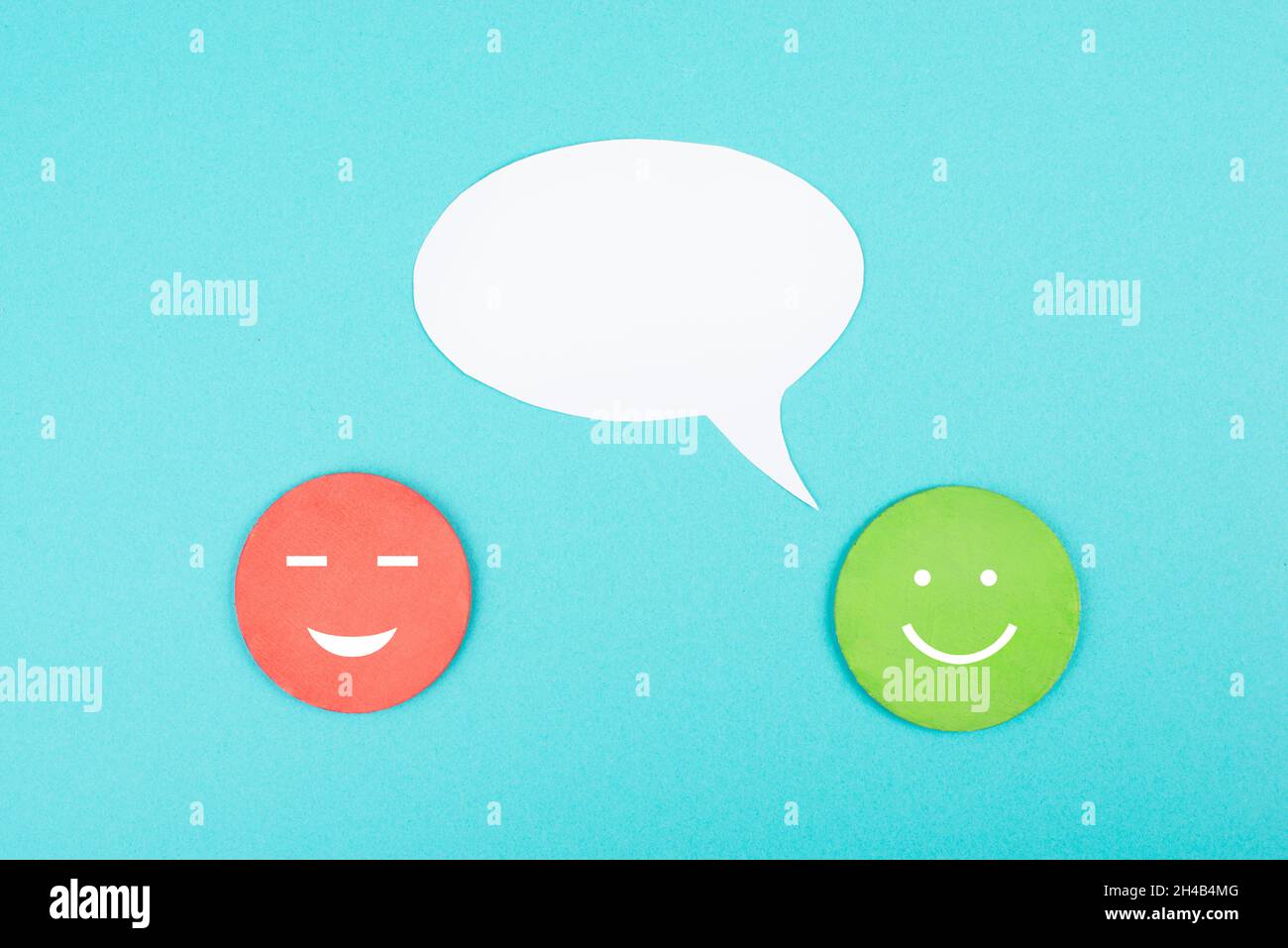 Smiling face with a speech bubble, blue colored background, copy space ...