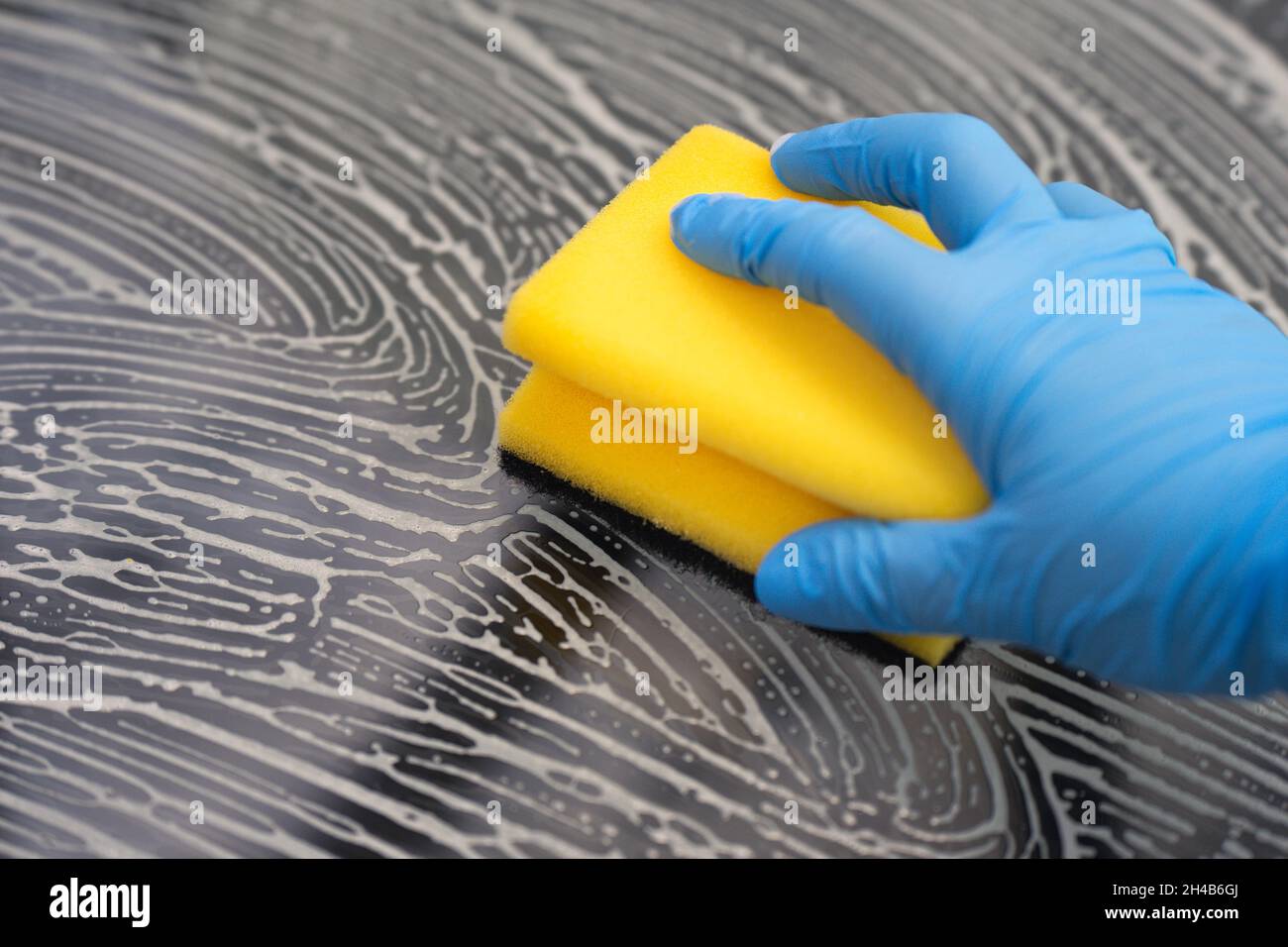 Hand cleaning glass table with detergent and glove Stock Photo - Alamy