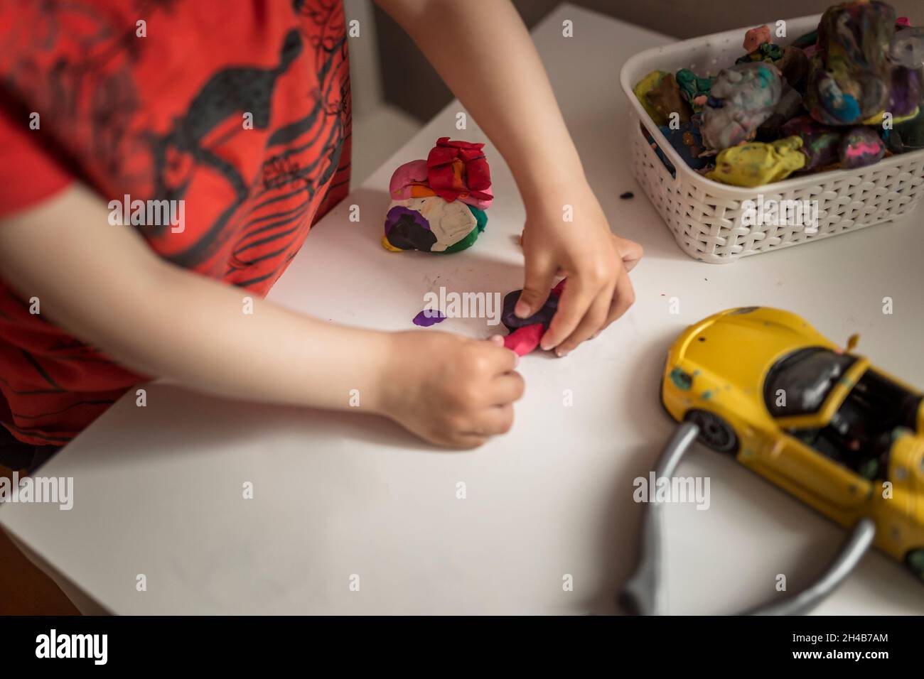 Hands of a child playing with play doh on white table Stock Photo - Alamy