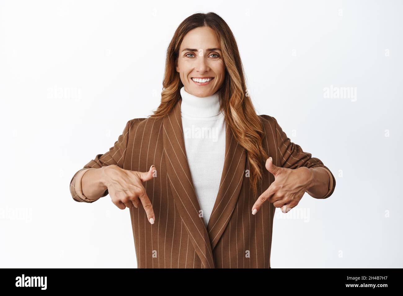 Smiling female entrepreneur, business woman pointing fingers down at ...