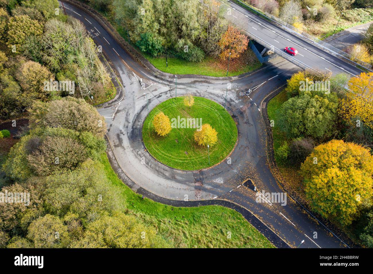 Aerial drone view of a small traffic roundabout surrounded by colourful ...