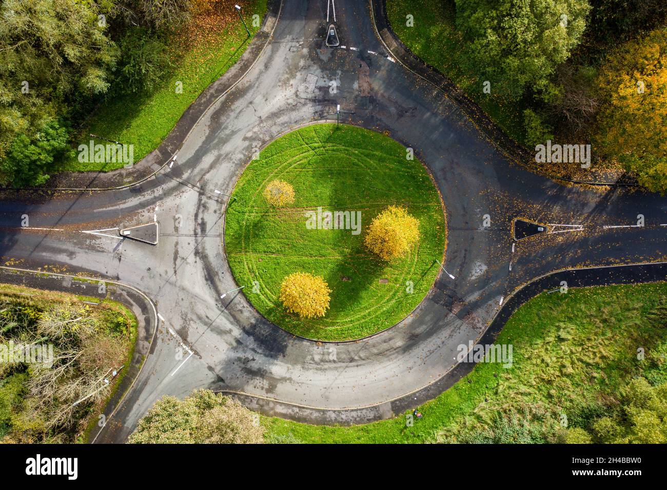 Top down aerial drone view of a small traffic roundabout surrounded by ...