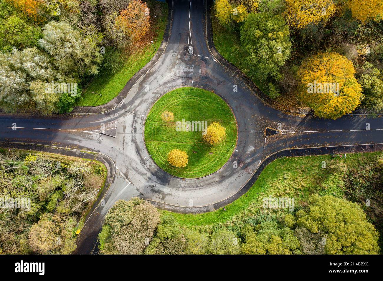 Aerial drone view of a small traffic roundabout surrounded by colourful ...