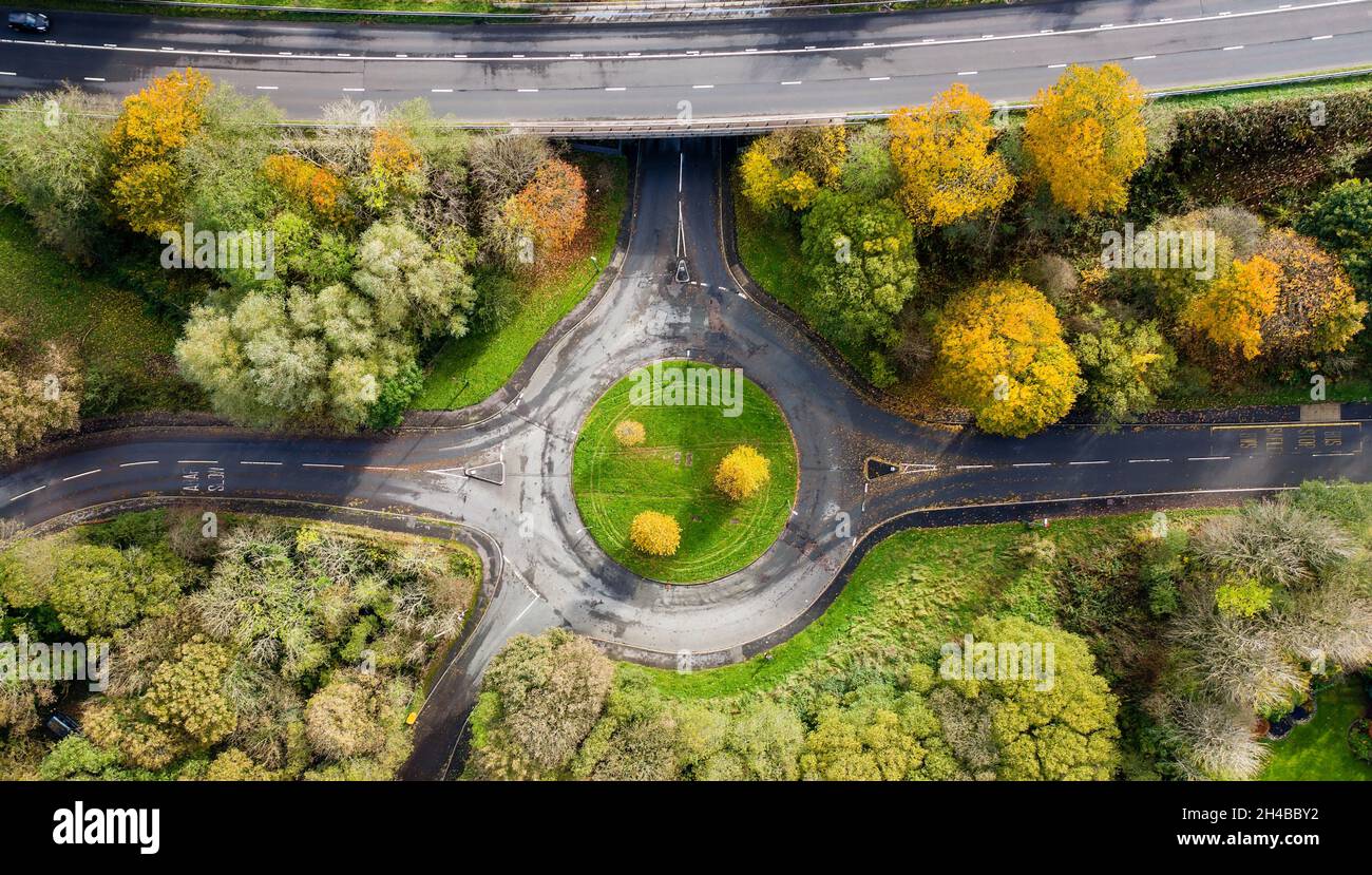 Aerial drone view of a small traffic roundabout surrounded by colourful ...