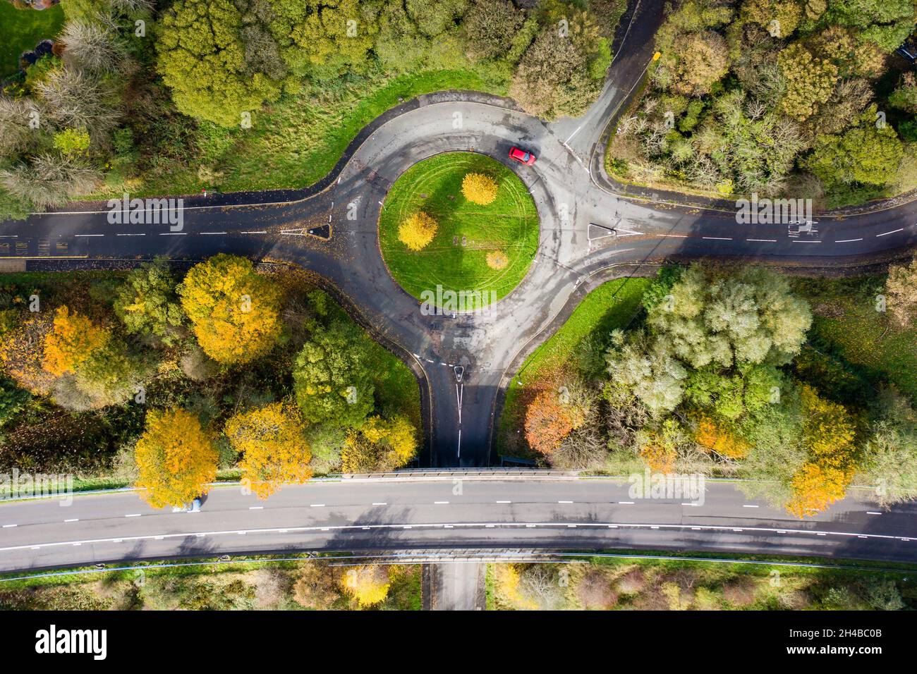 Aerial drone view of a small traffic roundabout surrounded by colourful ...