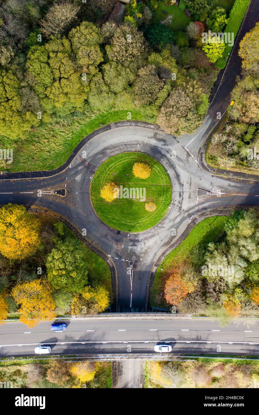 Aerial drone view of a small traffic roundabout with trees displaying ...