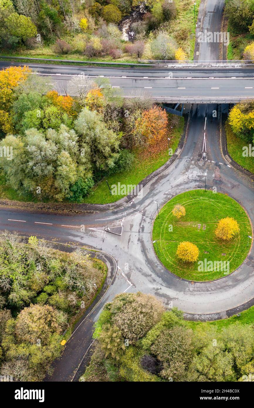 Aerial drone view of a small traffic roundabout with trees displaying ...