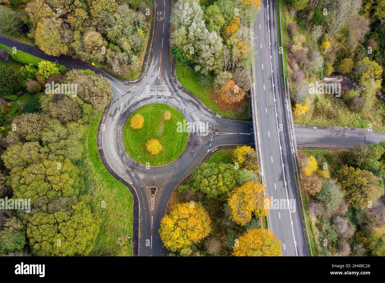 Aerial drone view of a small traffic roundabout surrounded by colourful ...
