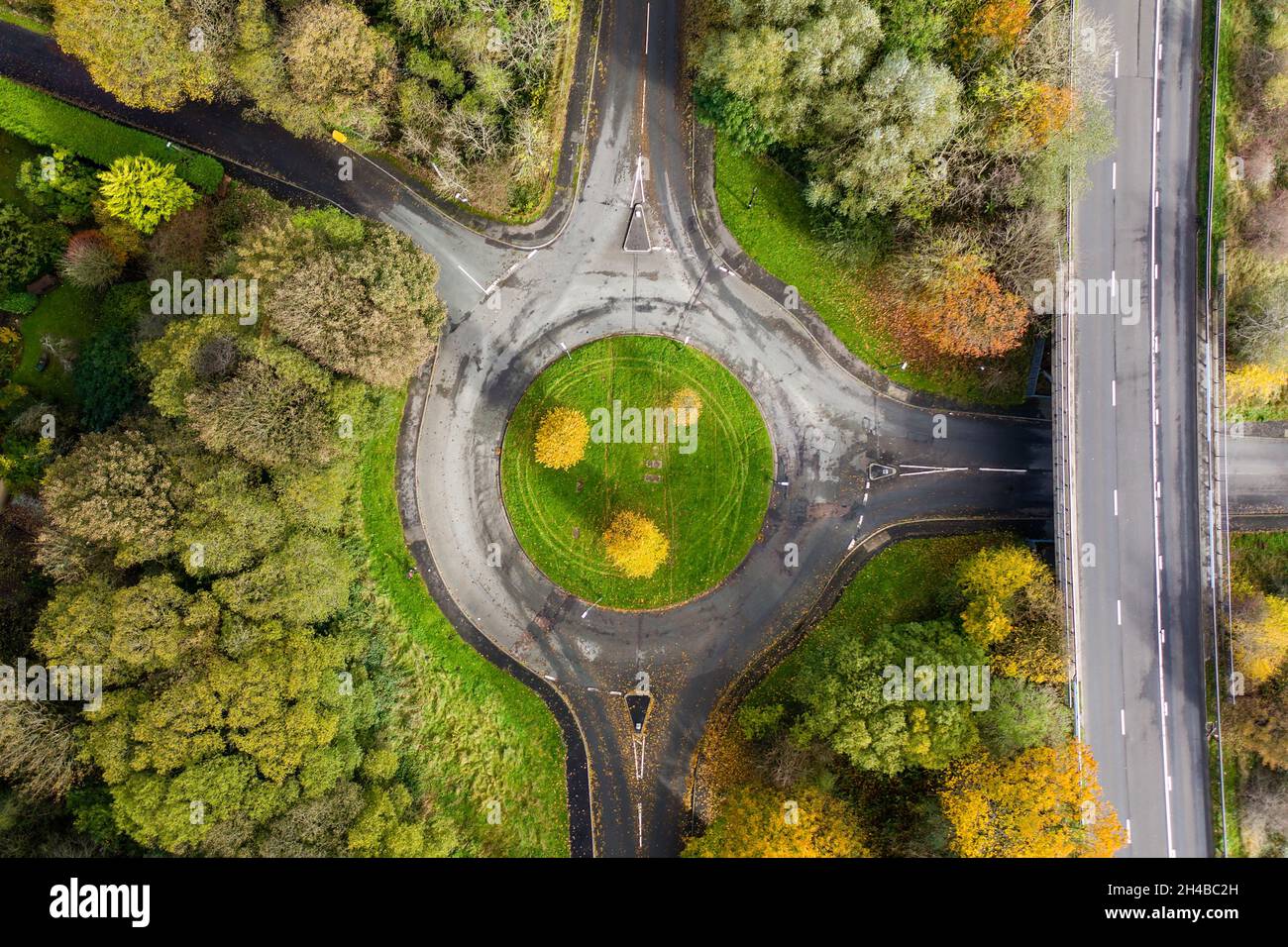 Aerial drone view of a small traffic roundabout surrounded by colourful ...