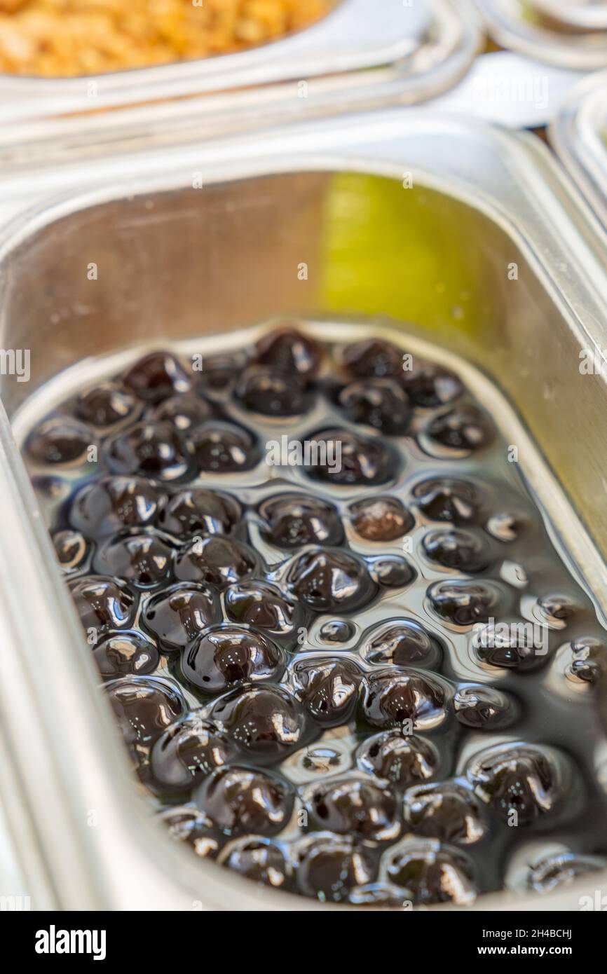 Tapioca pearls inside a container in the toppings window of a bubble ...