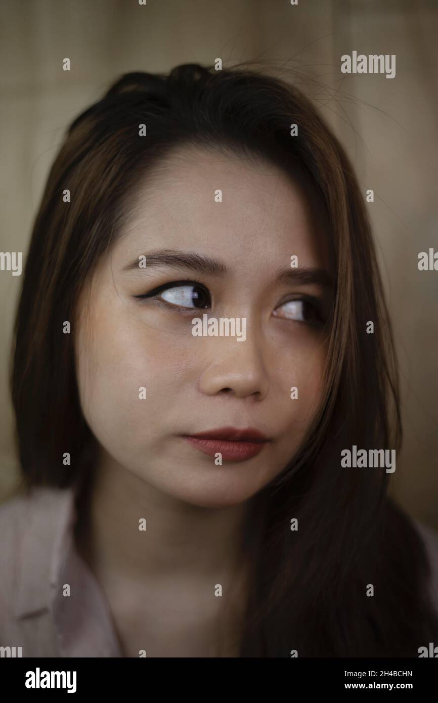 Cute Vietnamese lady looking at something against a blurred background Stock Photo - Alamy
