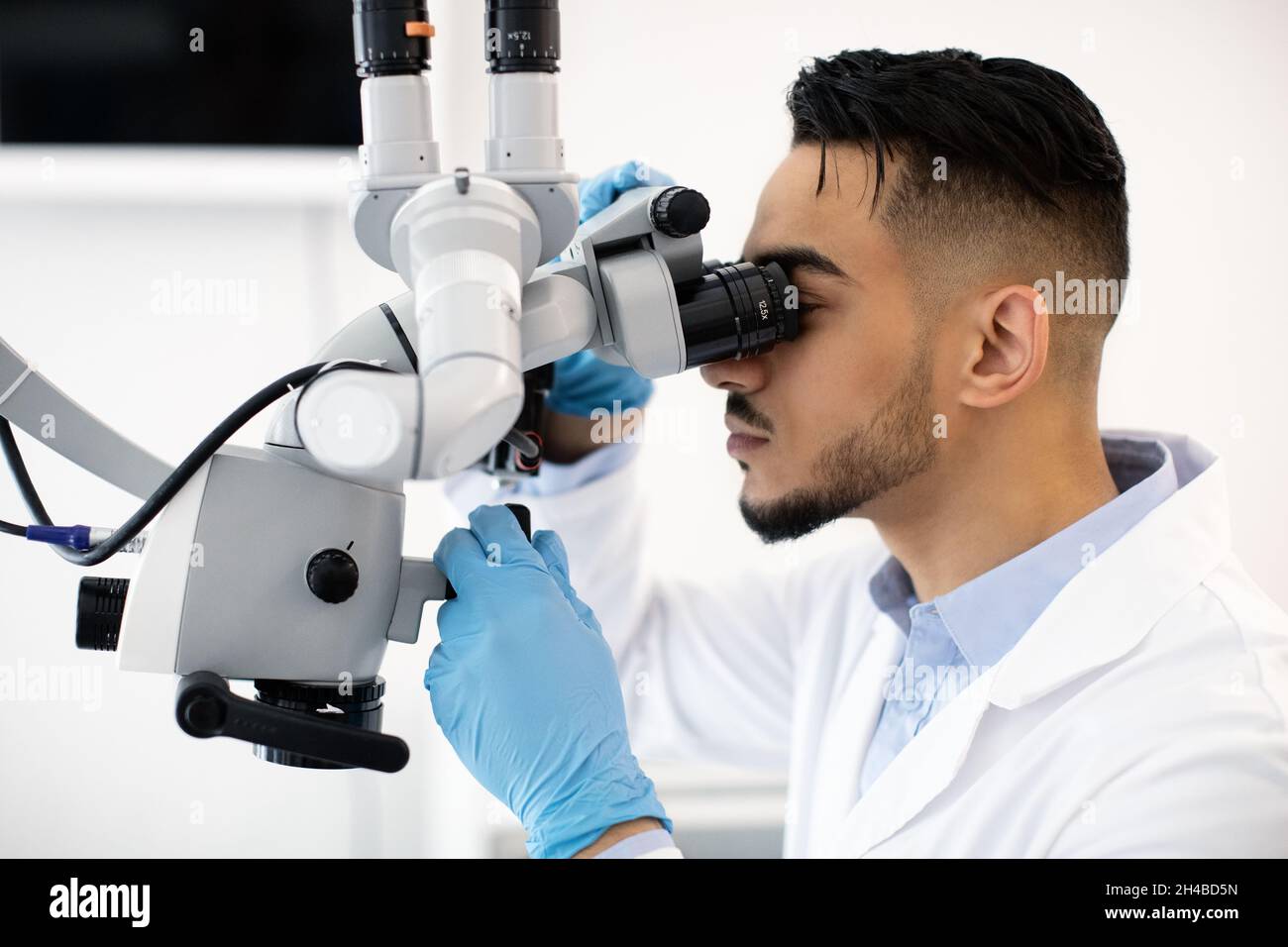 Young Arab Dentist Doctor Using Dental Microscope At Workplace In ...