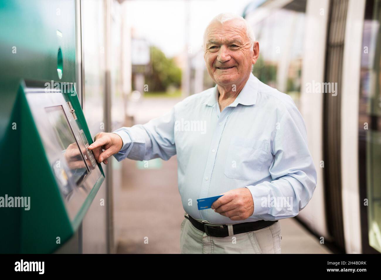 Elderly man using cash machine Stock Photo - Alamy