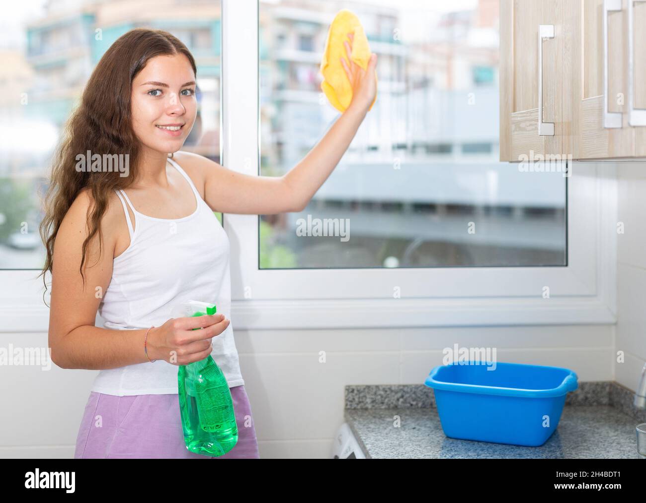 Young positive woman doing chores cleaning window Stock Photo - Alamy