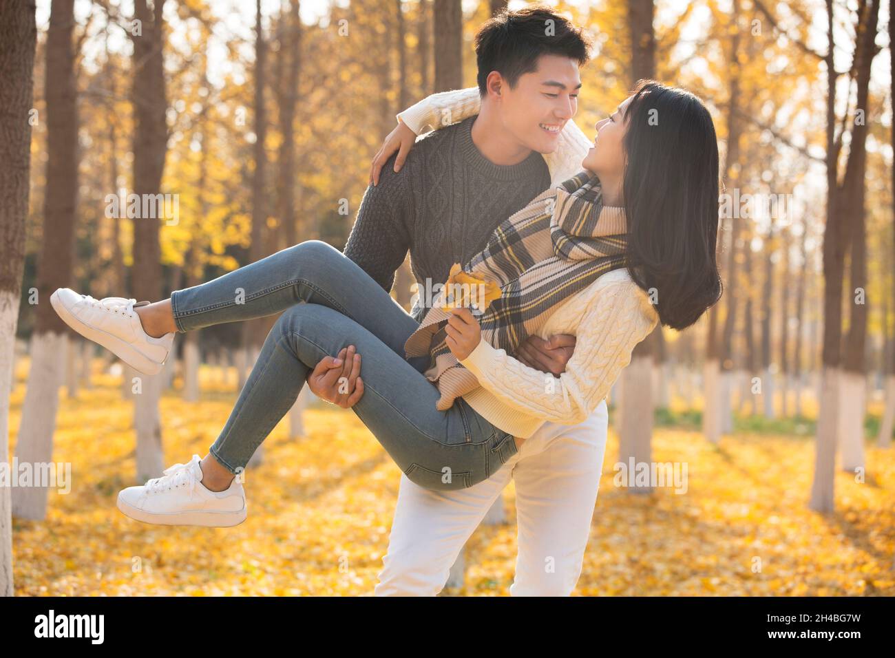 Young man picking up his girlfriend Stock Photo - Alamy