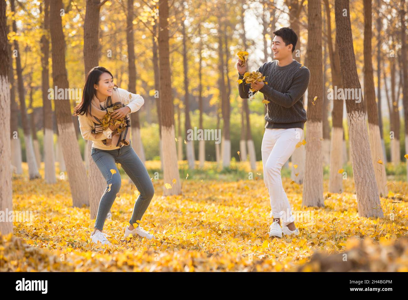 Happy young lovers frolicking in the woods Stock Photo - Alamy