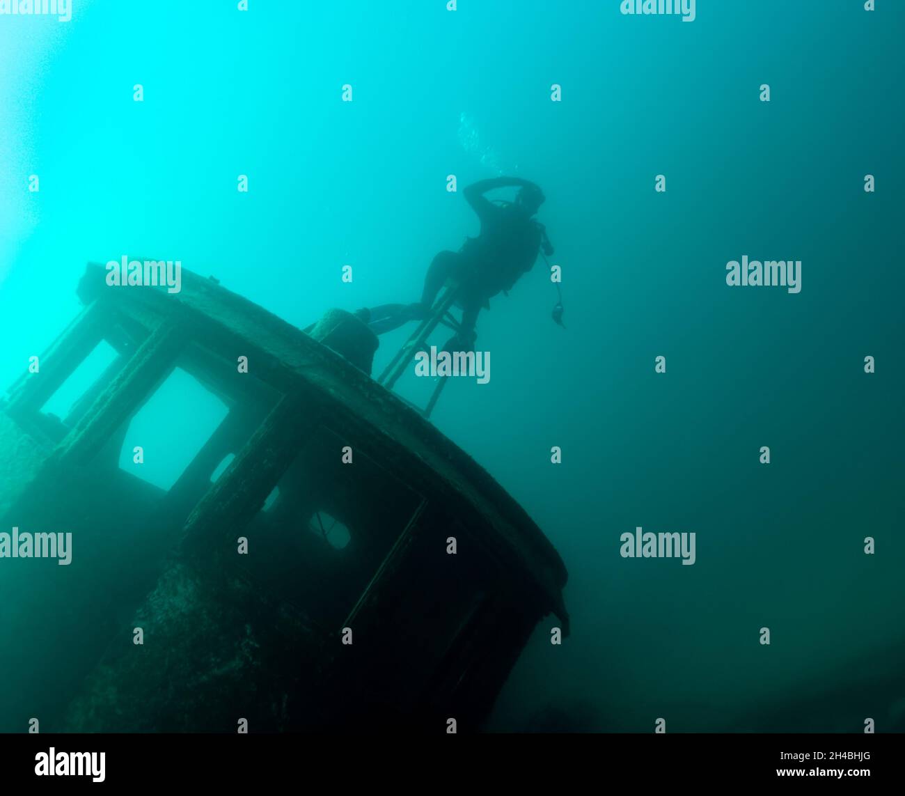 Diver saluting while on a tugboat shipwreck in Lake Superior Stock ...