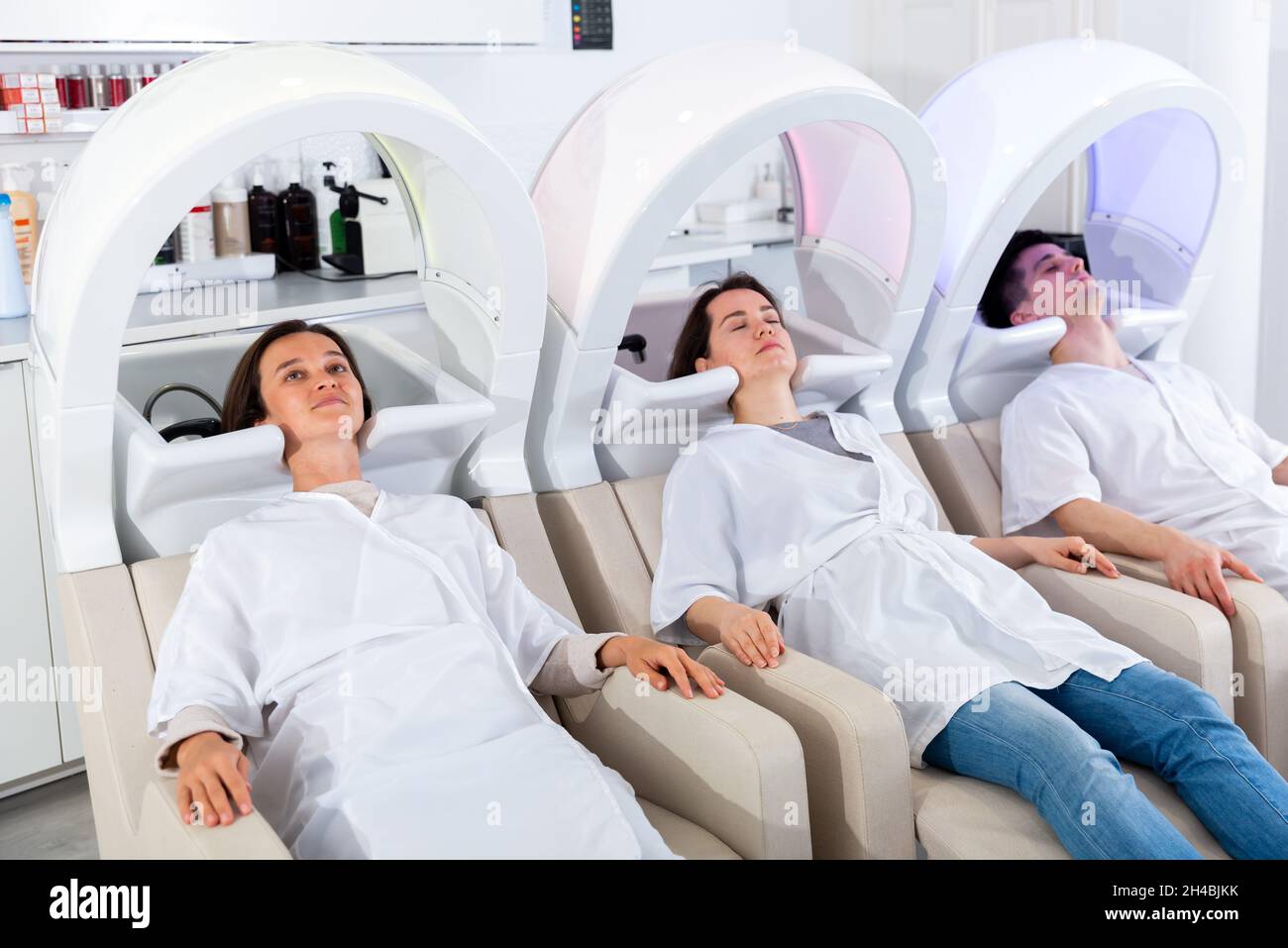Clients of beauty salon relaxing on massaging chairs Stock Photo - Alamy