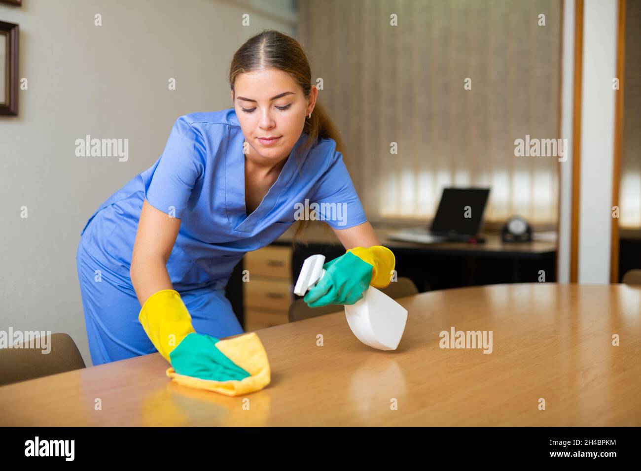 Portrait of a young female worker cleaning an office desk Stock Photo ...