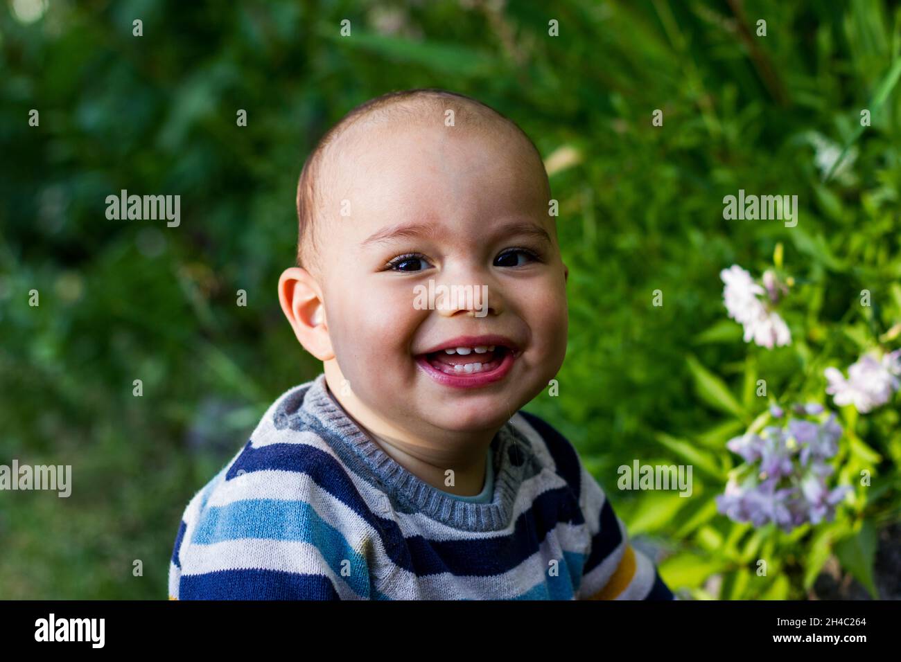 Cute little baby boy outdoors. Happy smiling baby at the green garden Stock Photo - Alamy