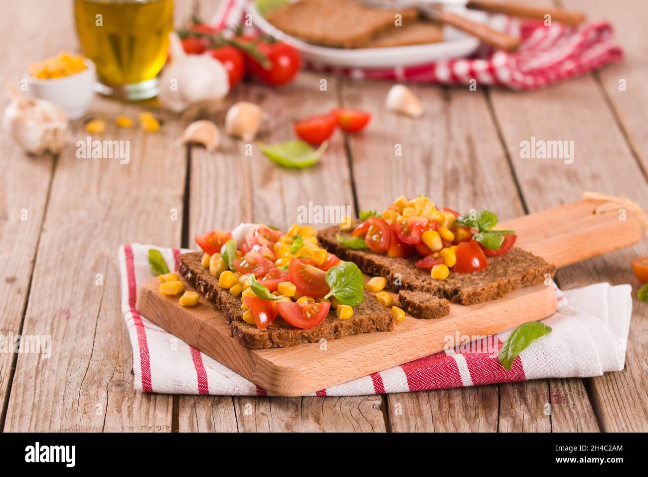 Rye bread withsweet corn, basil and tomato Stock Photo - Alamy