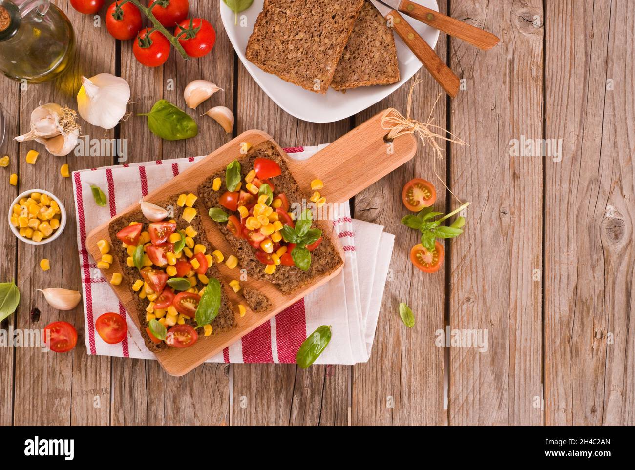 Rye bread withsweet corn, basil and tomato Stock Photo - Alamy