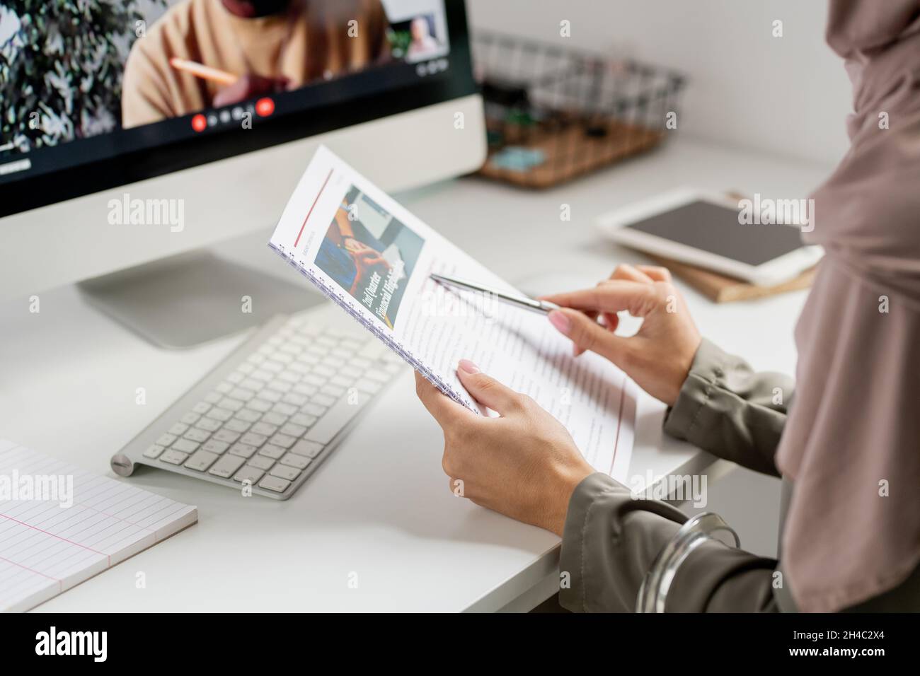 Hands of young contemporary teacher pointing at document while sitting ...