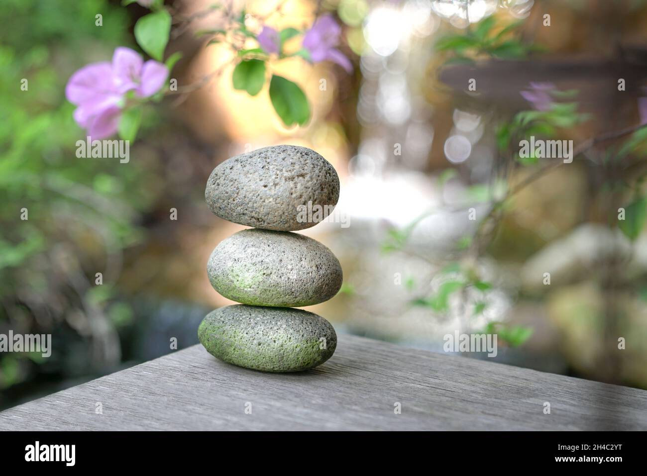 Stones stacked on top of each other, surrounded by nature flowers and ...