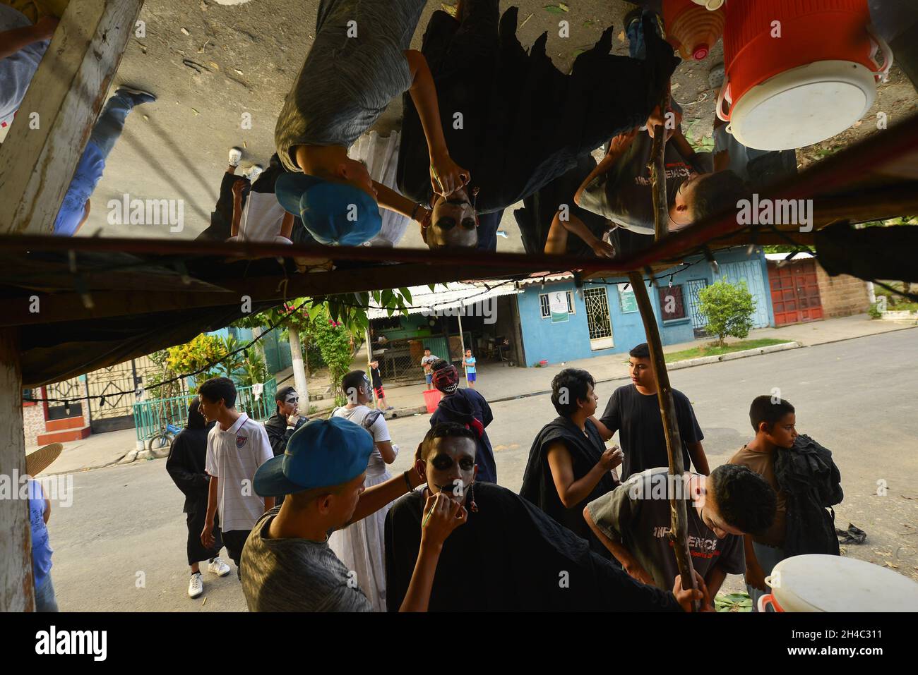 A reveler puts on makeup as he prepares for the celebration.Salvadorans ...