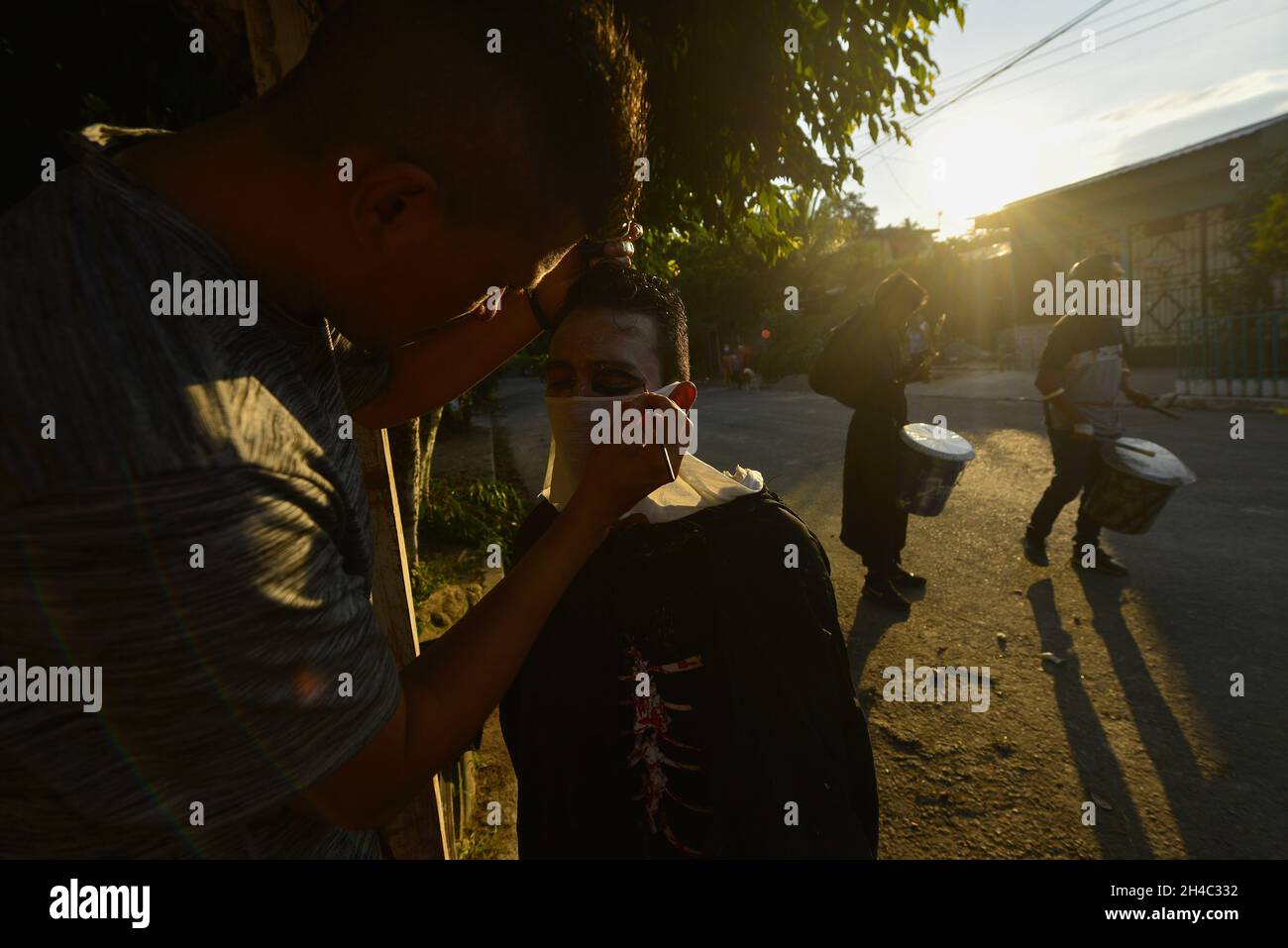 A reveler puts on makeup as he prepares for the celebration.Salvadorans ...