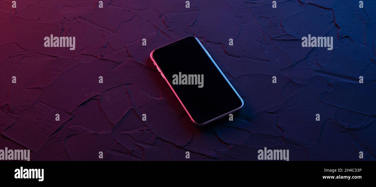 Mobile smartphone on dark red blue neon colors. Mock up.Perspective ...