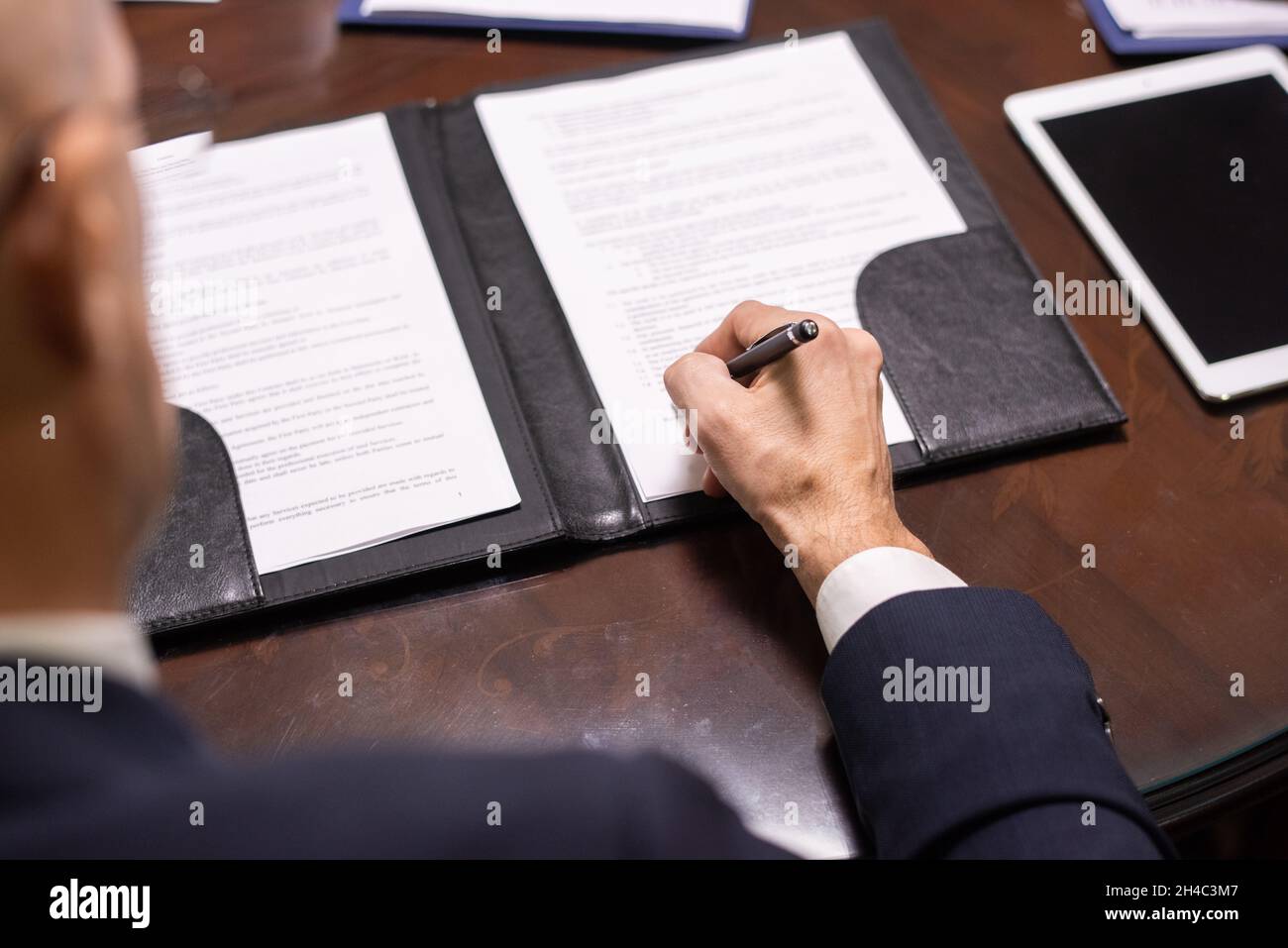 Hand of successful businessman with pen putting his signature on ...