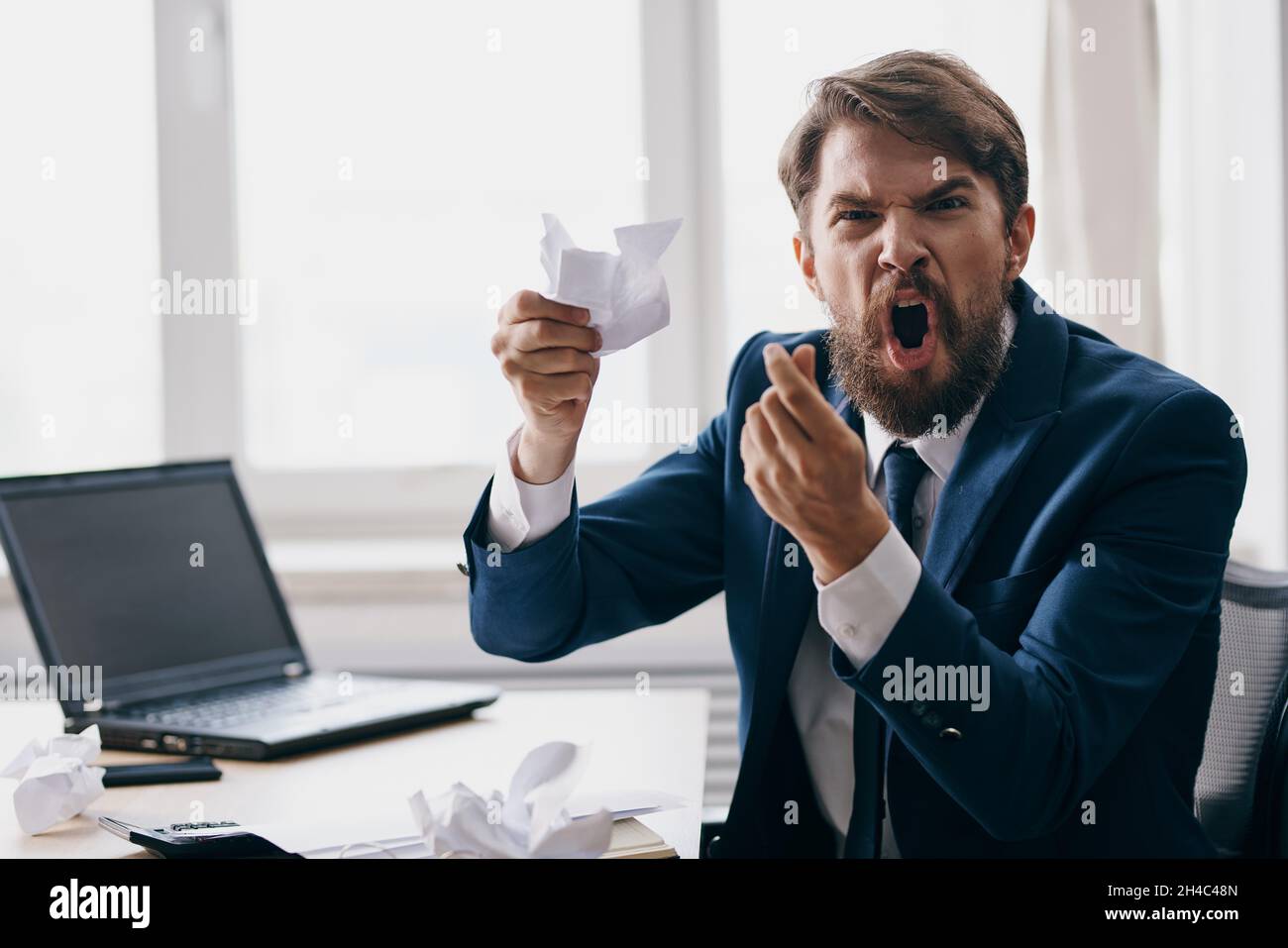 businessmen sitting at a desk in front of a laptop stress anger ...