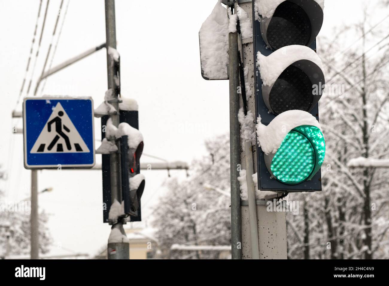 A working traffic light on a city street in winter.The traffic light is ...