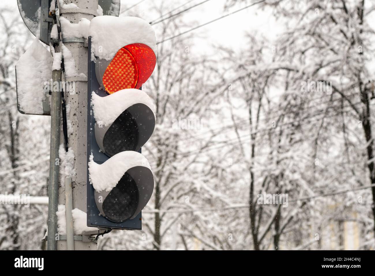 A working traffic light on a city street in winter.The red light of the ...