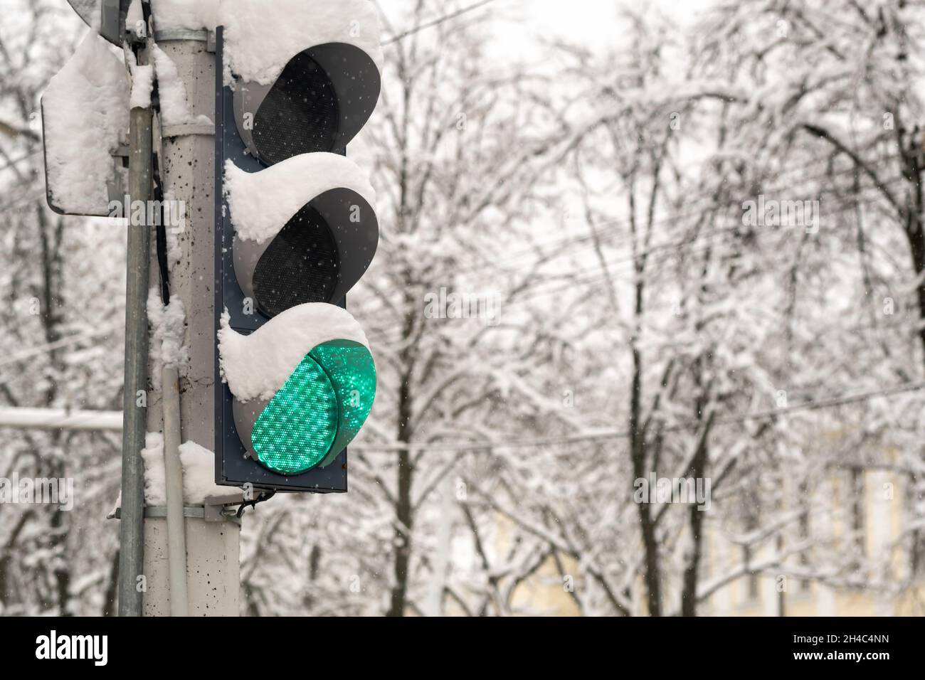 A working traffic light on a city street in winter.The traffic light is ...