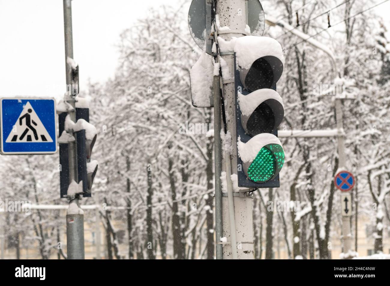 A working traffic light on a city street in winter.The traffic light is ...