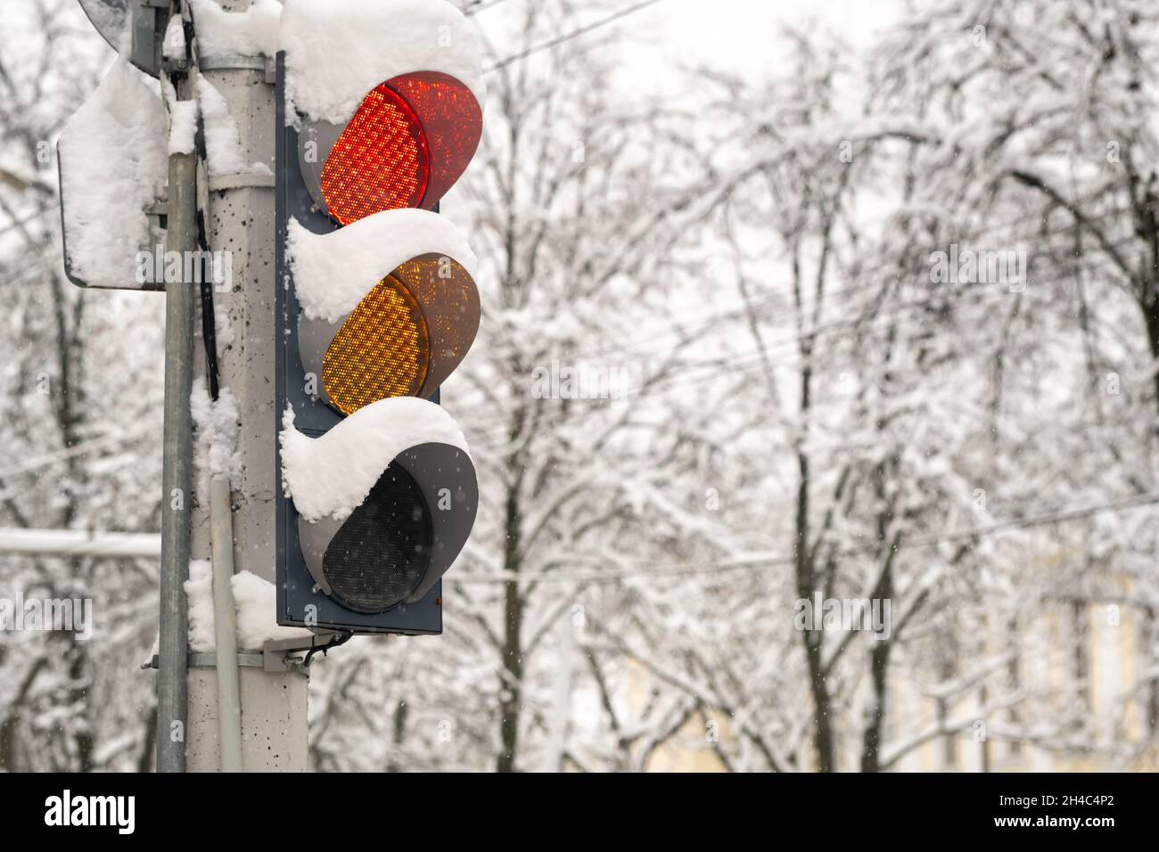 A working traffic light on a city street in winter.The red light of the ...