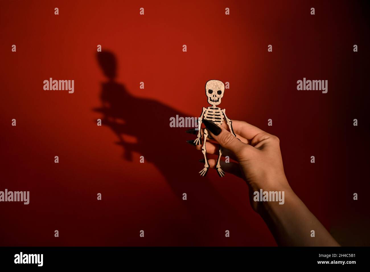 human skeleton toy in hand with a shadow. mock up Stock Photo - Alamy