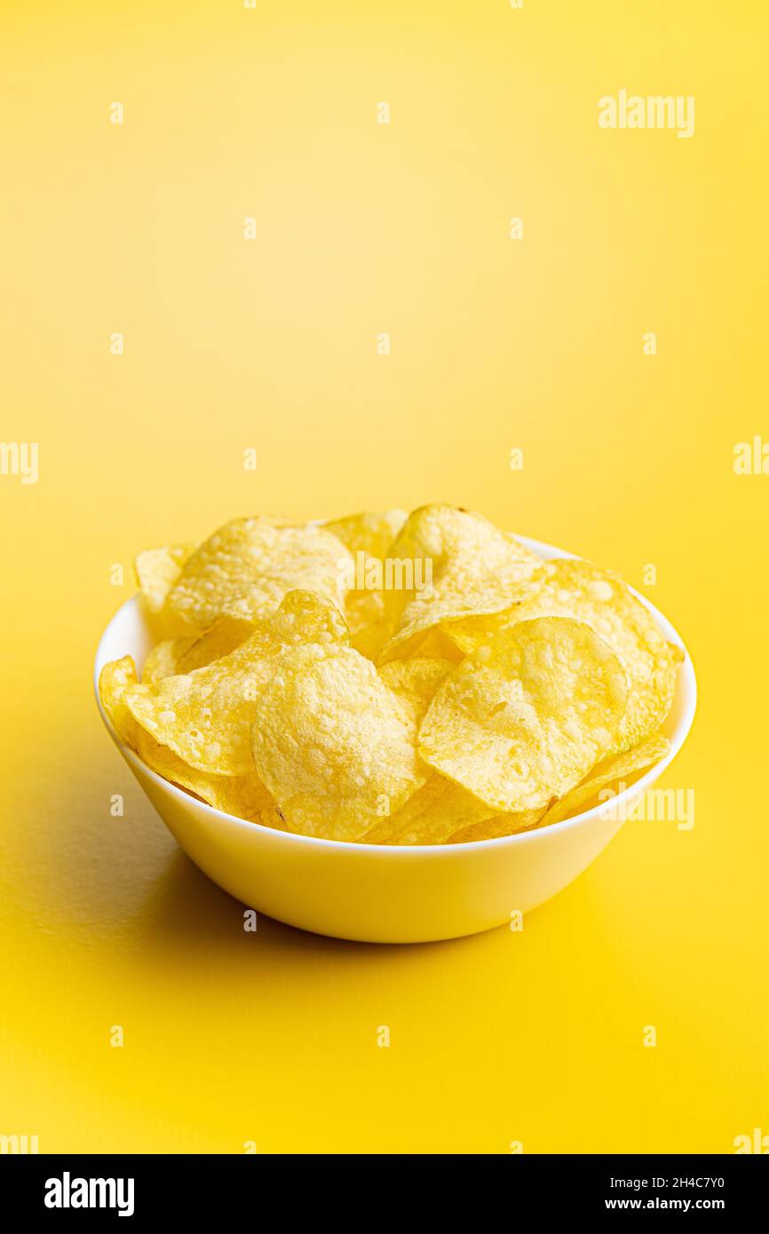 Crunchy potato chips. Potato crisps on yellow background Stock Photo ...