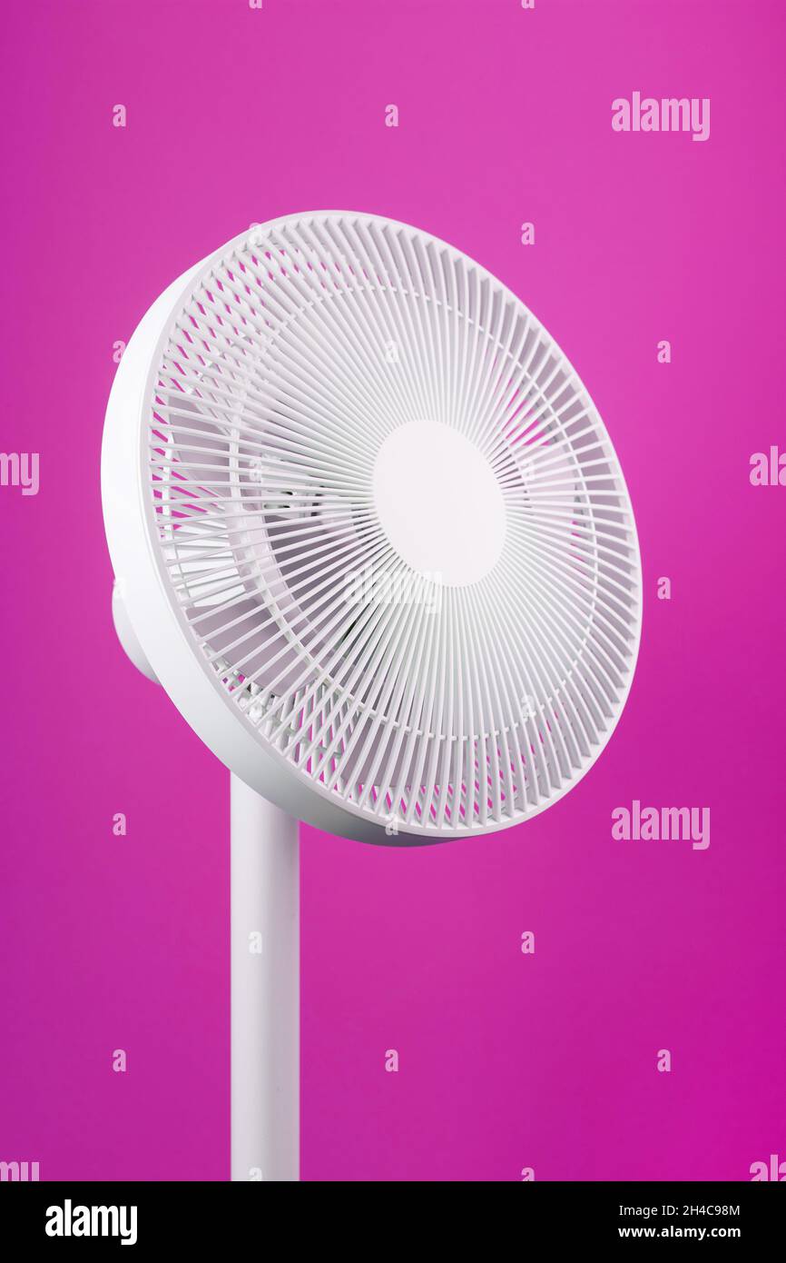 A high-tech white electric fan with a modern design for cooling the ...