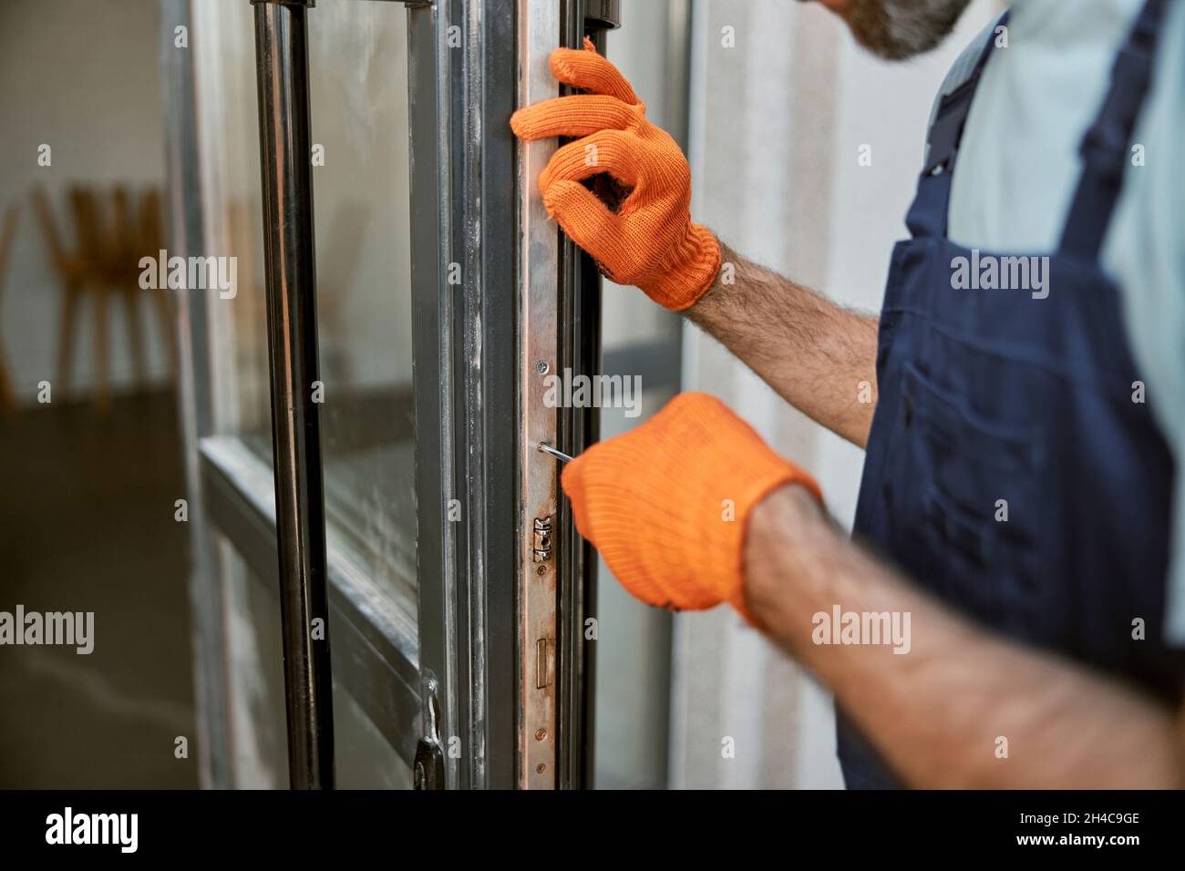 Male hands in gloves fixing door in house Stock Photo - Alamy