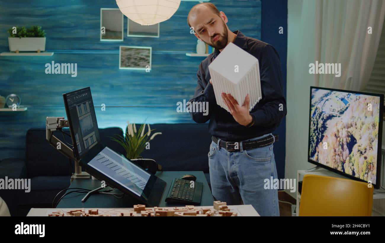 Man Architect Checking Maquette In Hand With Model On Monitor Engineer Using Touch Screen For