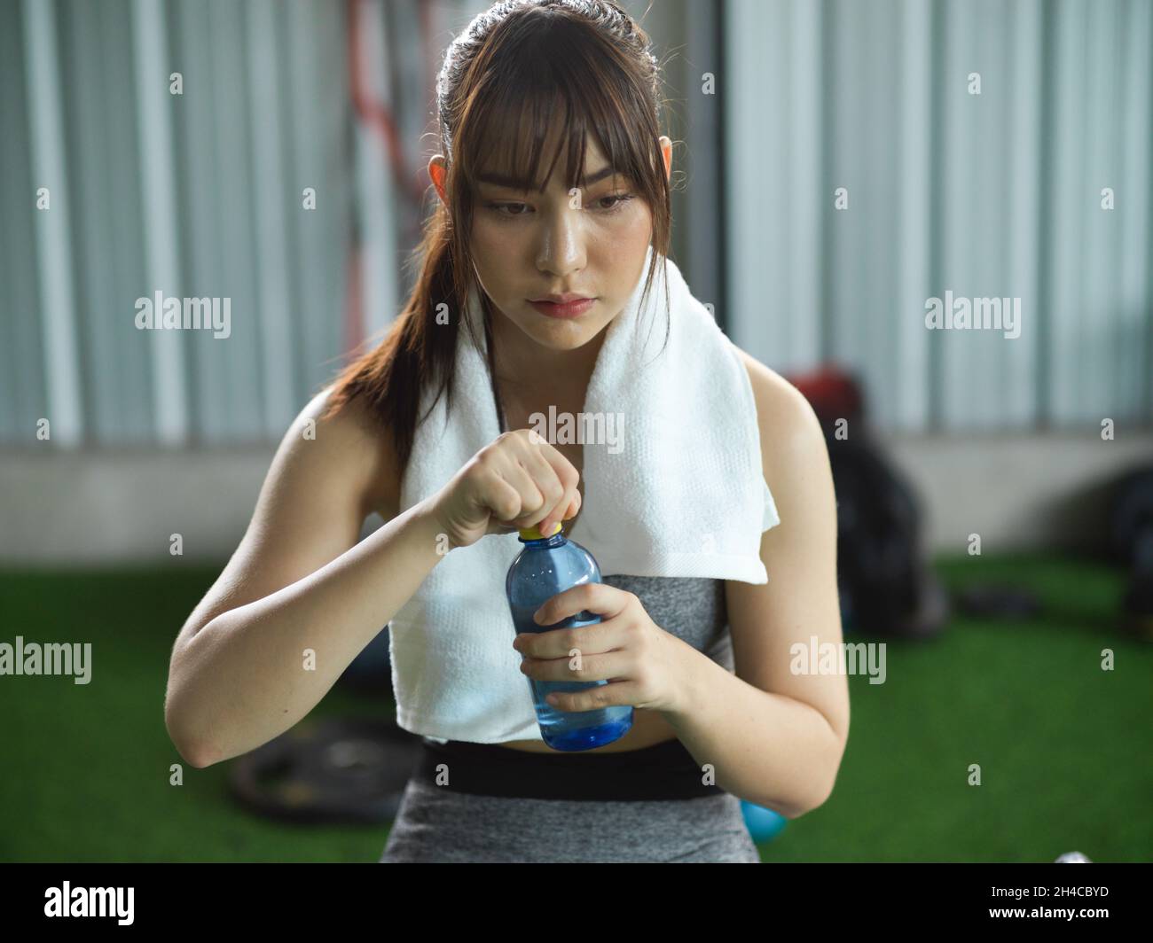 Exhausted fitness woman take some rest and hold vitamin drinking water ...