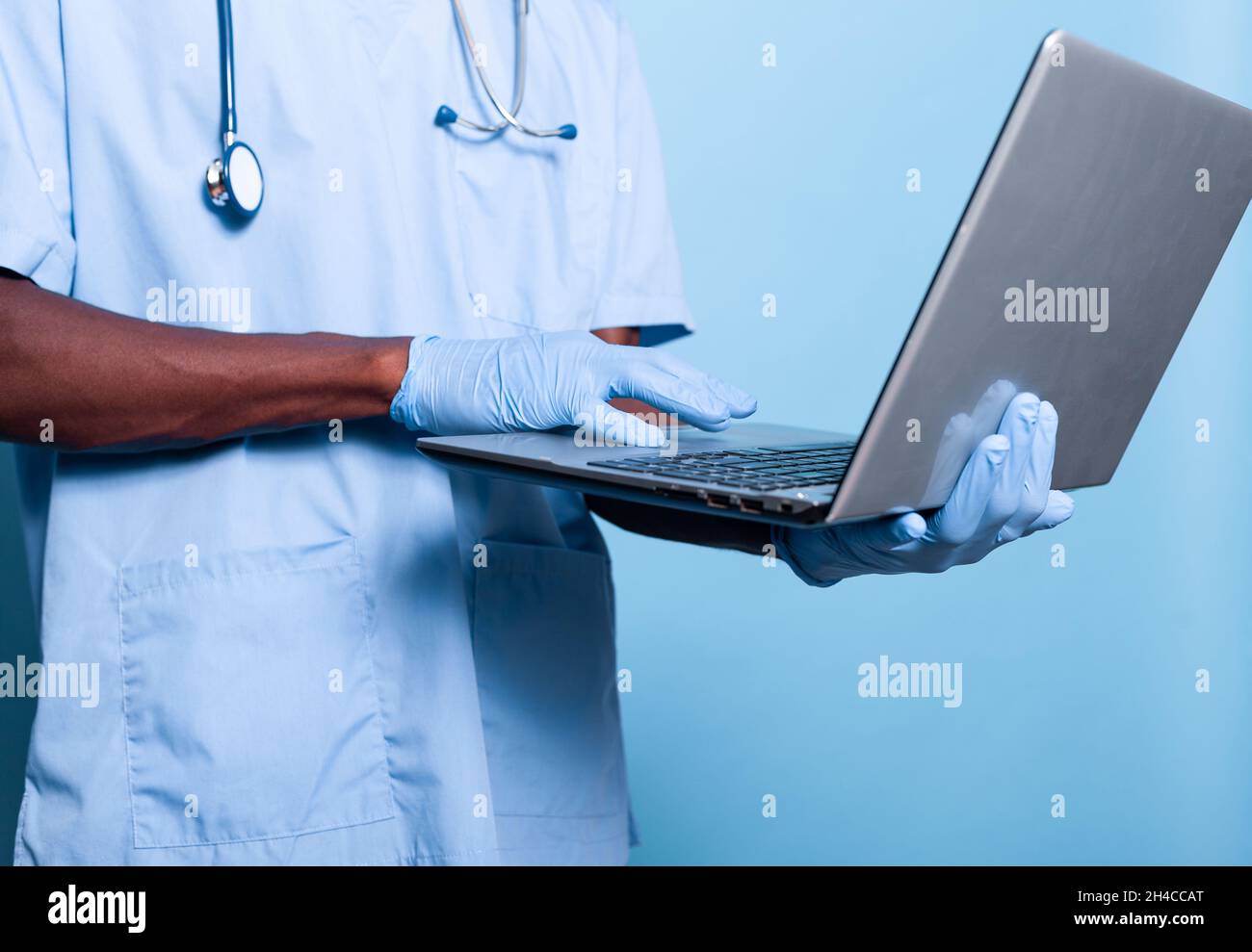 Close up of hands of medical assistant holding laptop. Man working as ...