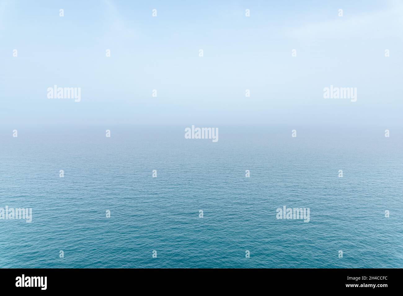 Abstract infinity sea view with small wave pattern and fog on horizon ...